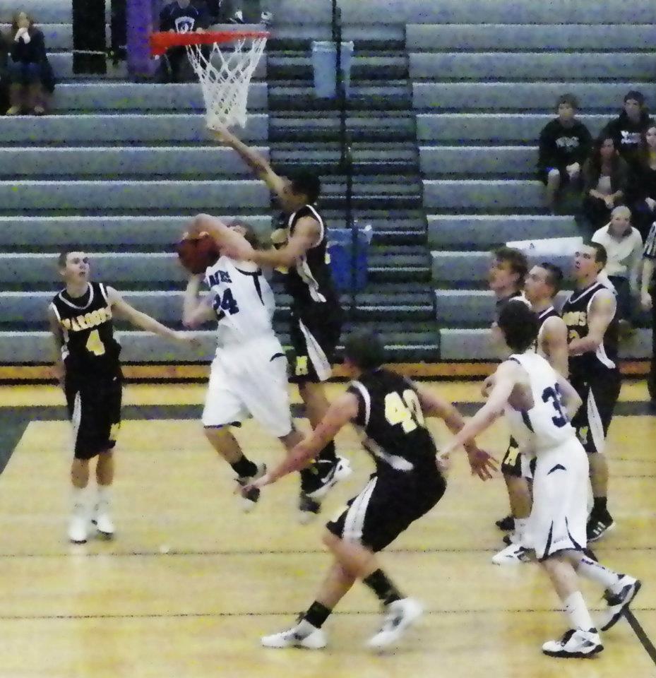 Pi ctured left: Cody Frazer (32) throws up a jumper as Menominee's ...